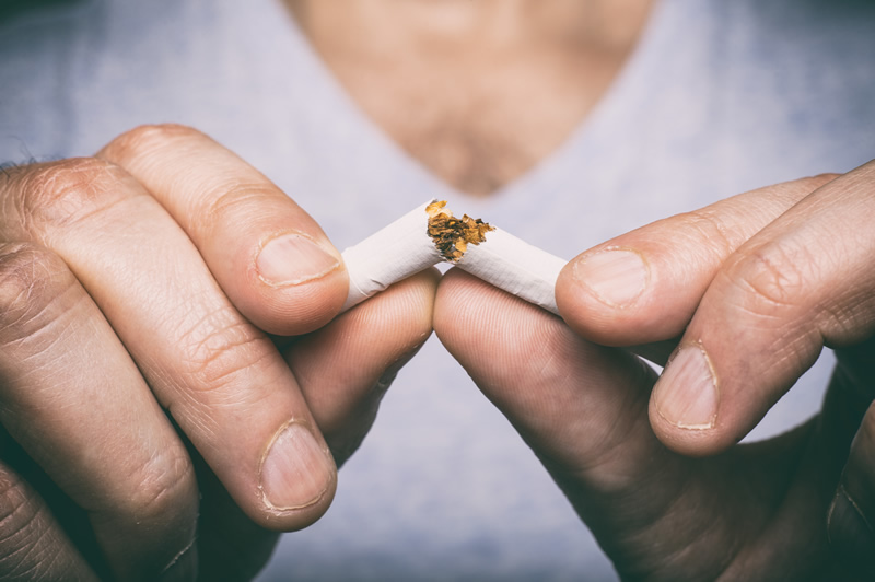 person-breaking-cigarette | Driven to Wellness